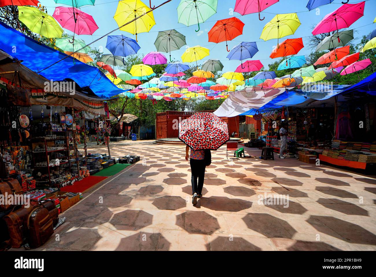 Delhi, Uttar Pradesh, India. 21st Apr, 2023. A woman walks with an ...