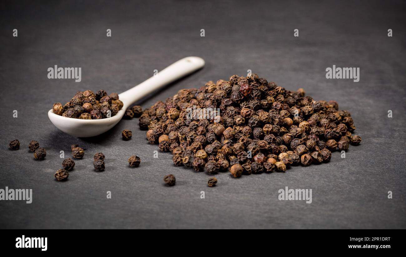 Dry ground black pepper corn spices for recipes. Spoon and a pile of ...