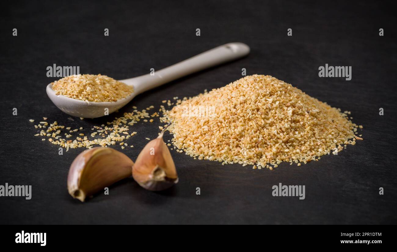 Garlic spice for recipes. Spoon and a pile of garlic powder. Garlic ...