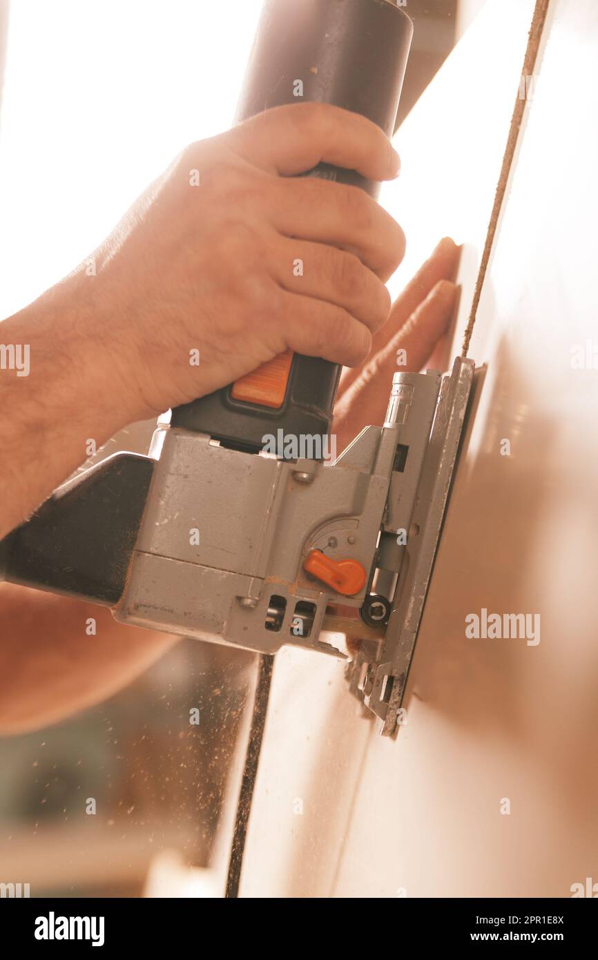 craftsman's hand with a cutting tool or sanding all seen against the ...