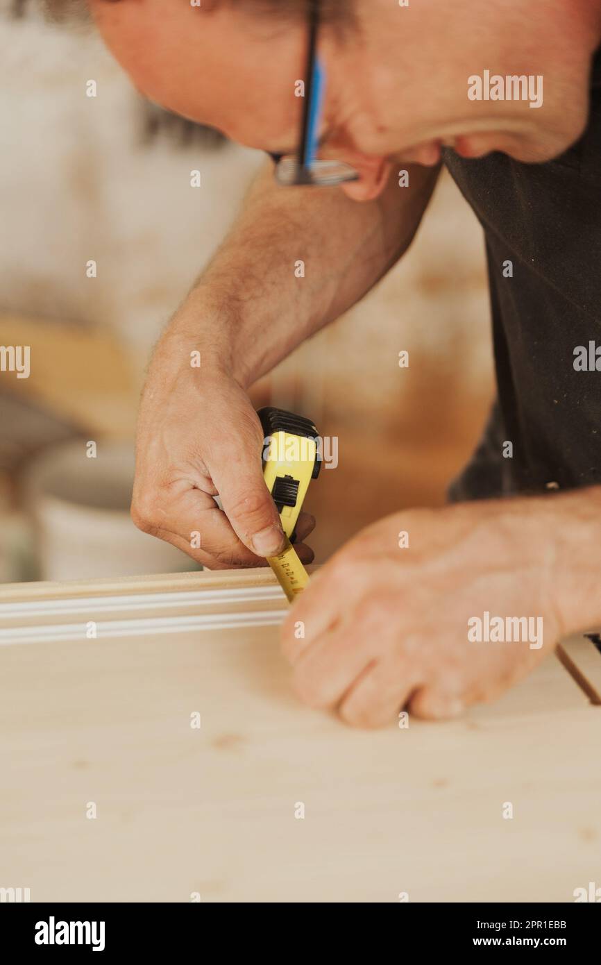 Carpenter squints to get a good read on the measurement he is taking ...