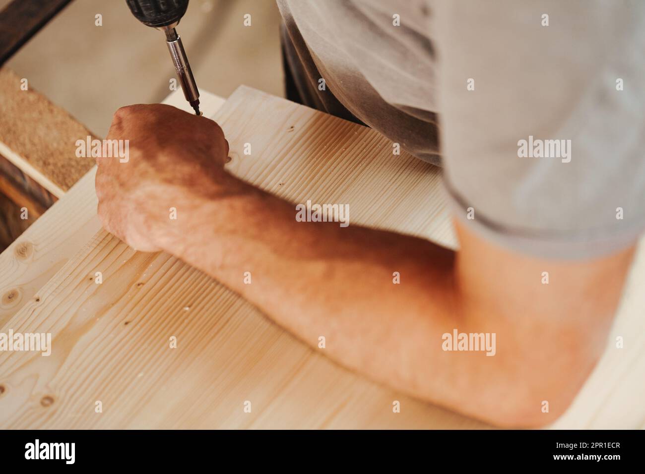 Detail in focus on the action of screwing a hinge onto a handcrafted ...