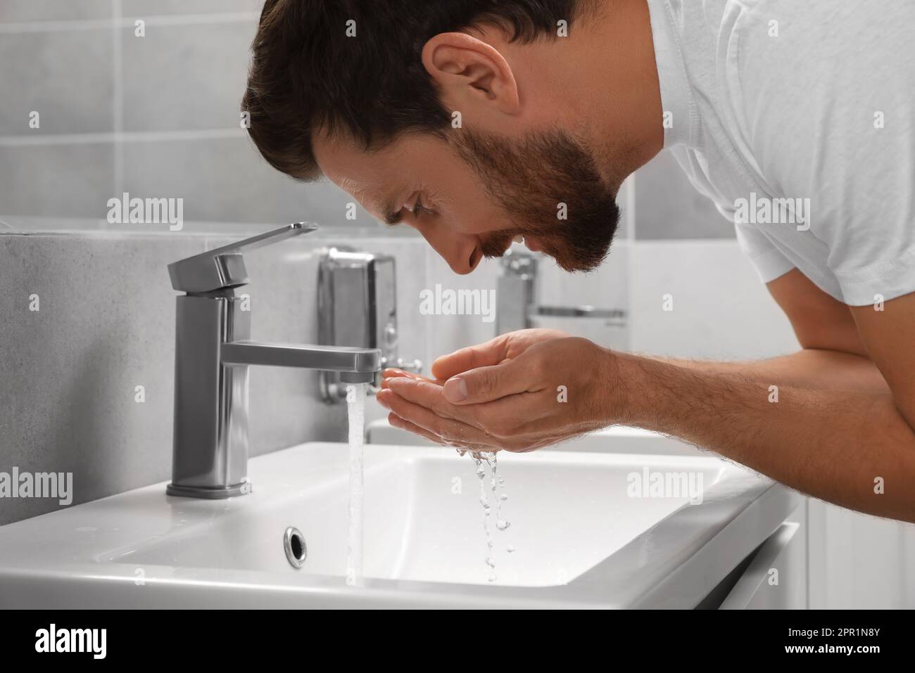 Man washing face in sink hi-res stock photography and images - Alamy