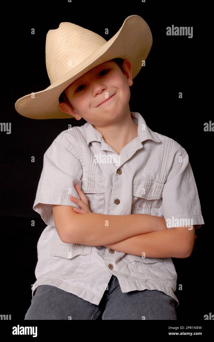 Young boy wearing a cowboy hat isolated on black Stock Photo - Alamy