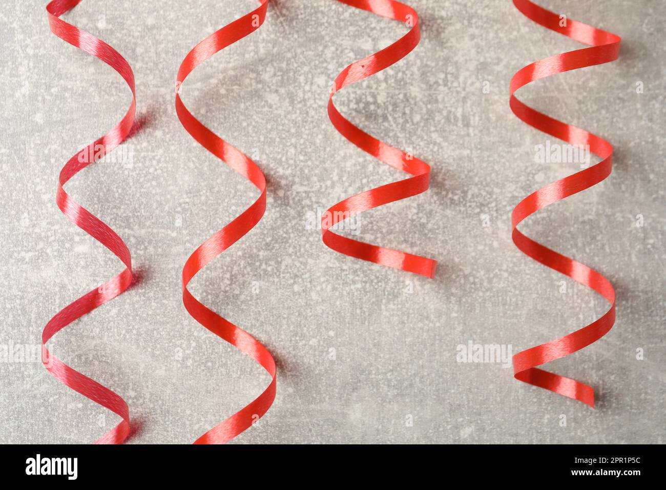Shiny red serpentine streamers on grey background, flat lay Stock Photo ...