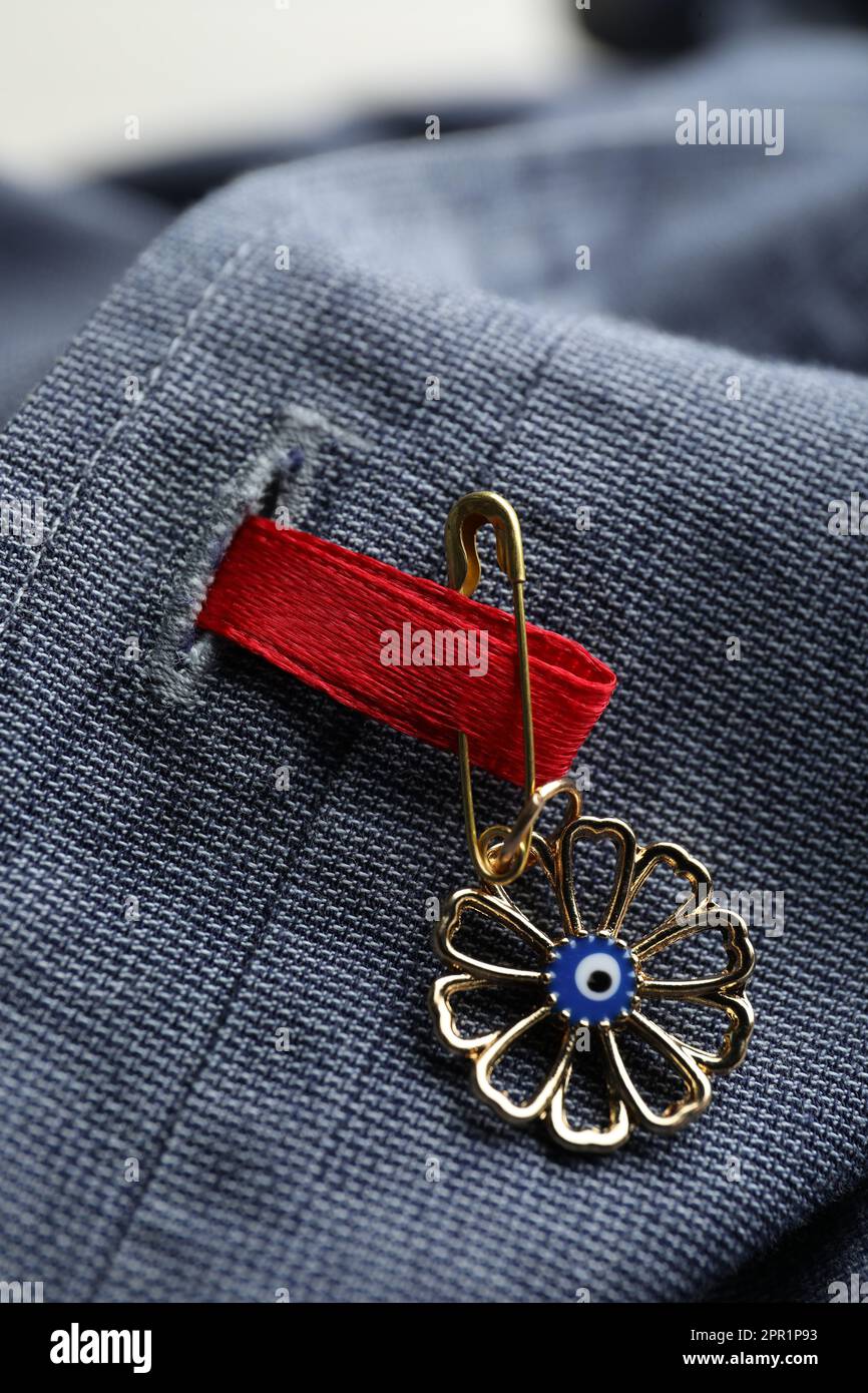 Evil eye safety pin on clothing, closeup Stock Photo - Alamy