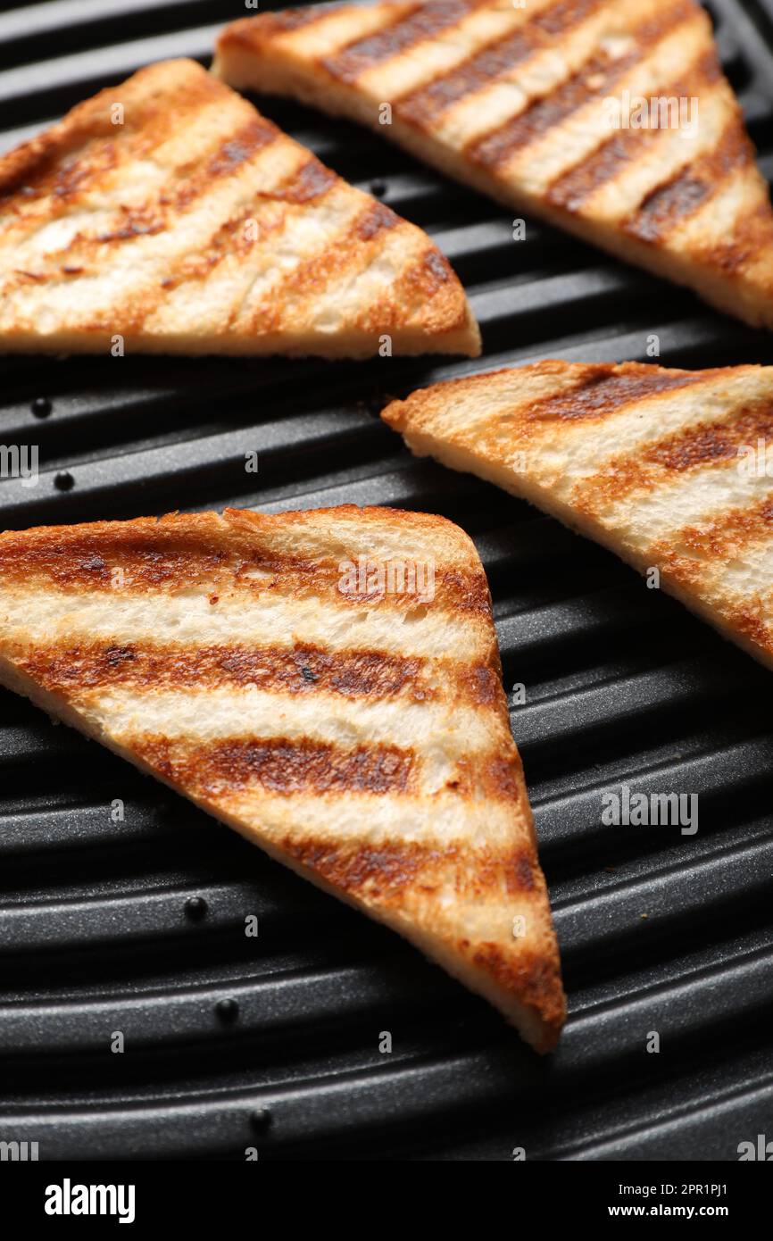 Modern sandwich maker with bread slices, closeup Stock Photo - Alamy