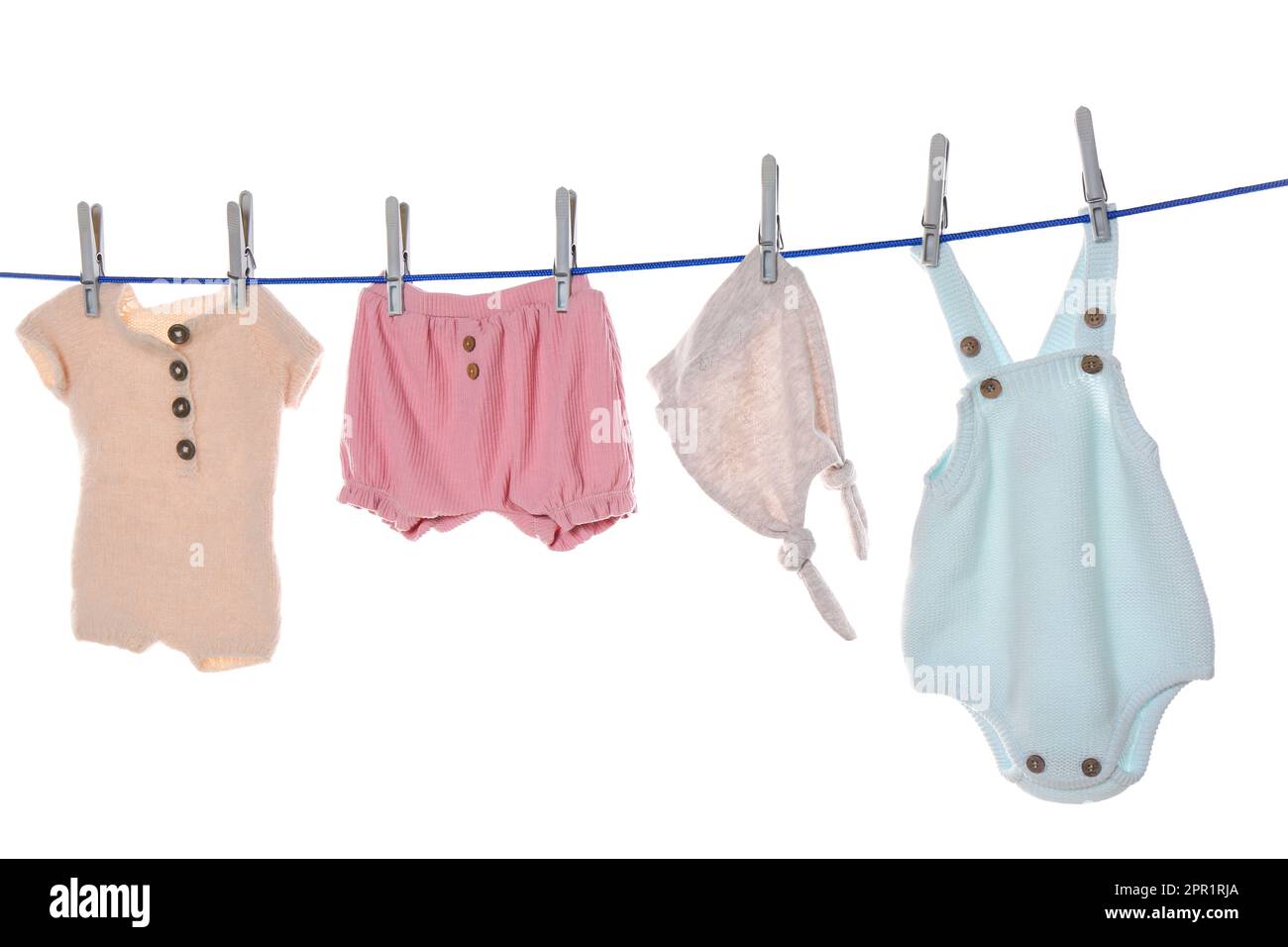 Colorful baby clothes drying on laundry line against white background ...