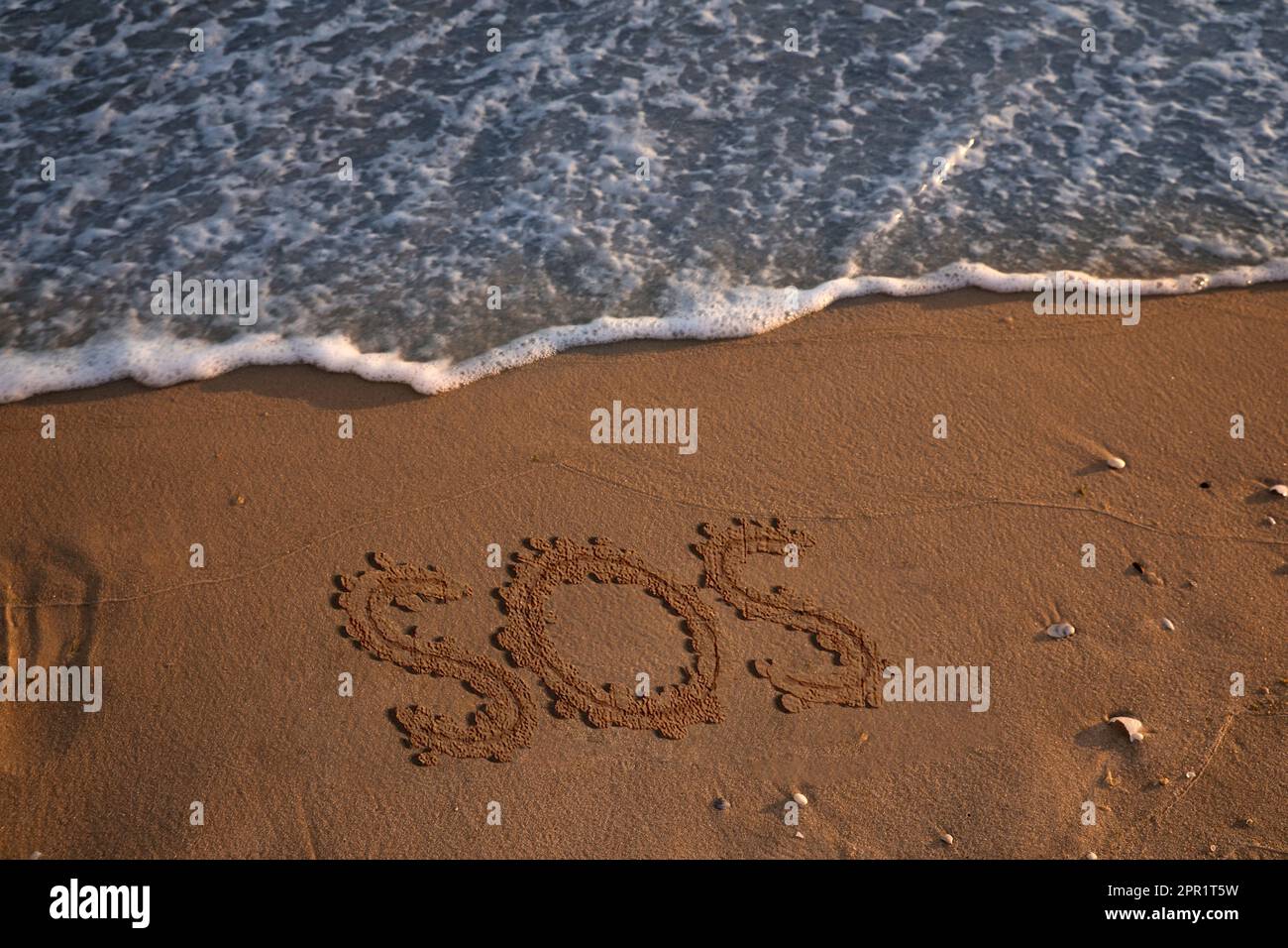 Sos message written on sand hi-res stock photography and images - Alamy