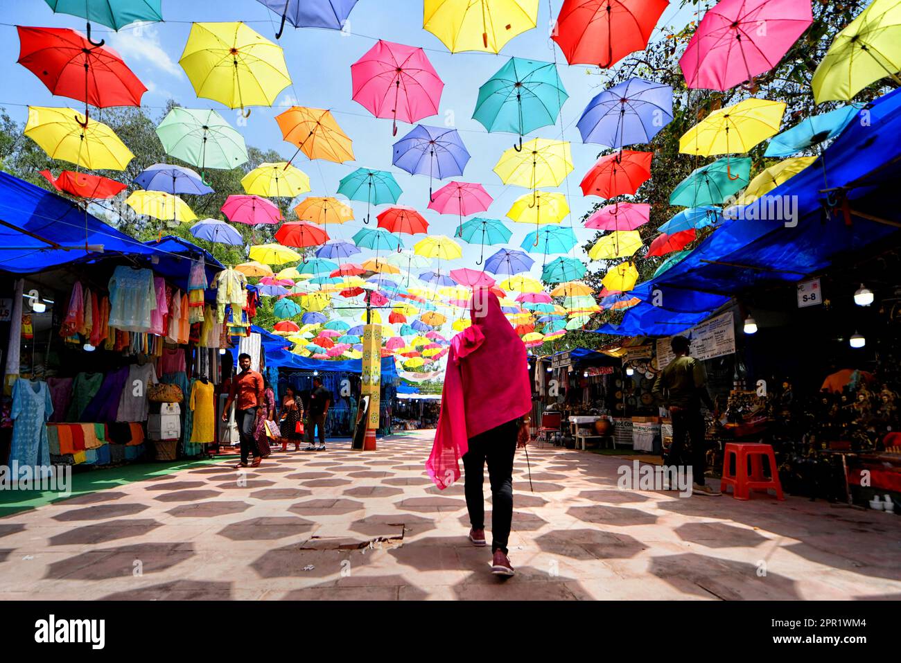 Delhi, India. 21st Apr, 2023. A woman walks under the Colorful Umbrella ...