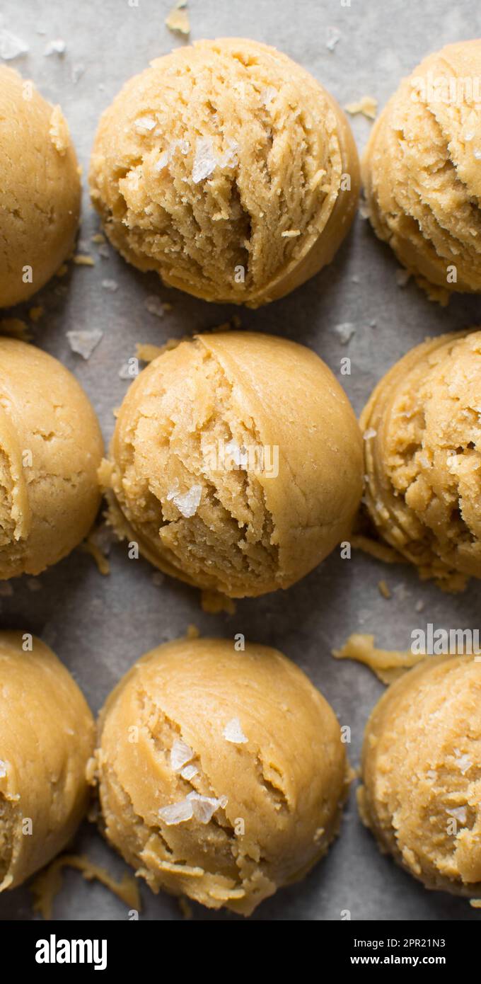 Scoops of vanilla cookie dough on a parchment lined cookie sheet, plain ...