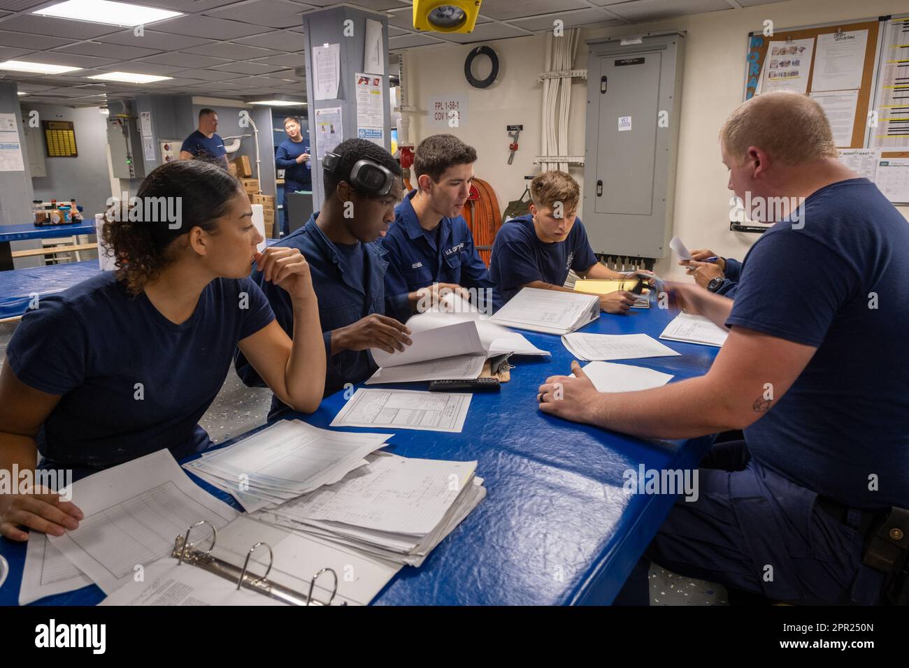 Crew members aboard Coast Guard Cutter Midgett (WMSL 757) go over the ...