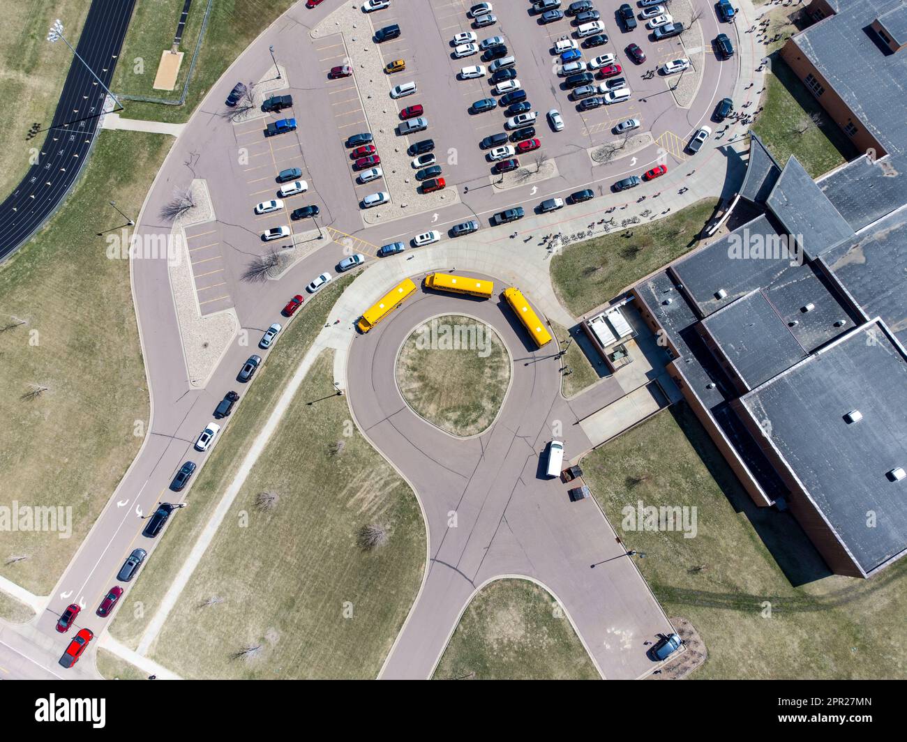 Drone overhead aerial view of a school letting out students at the end ...