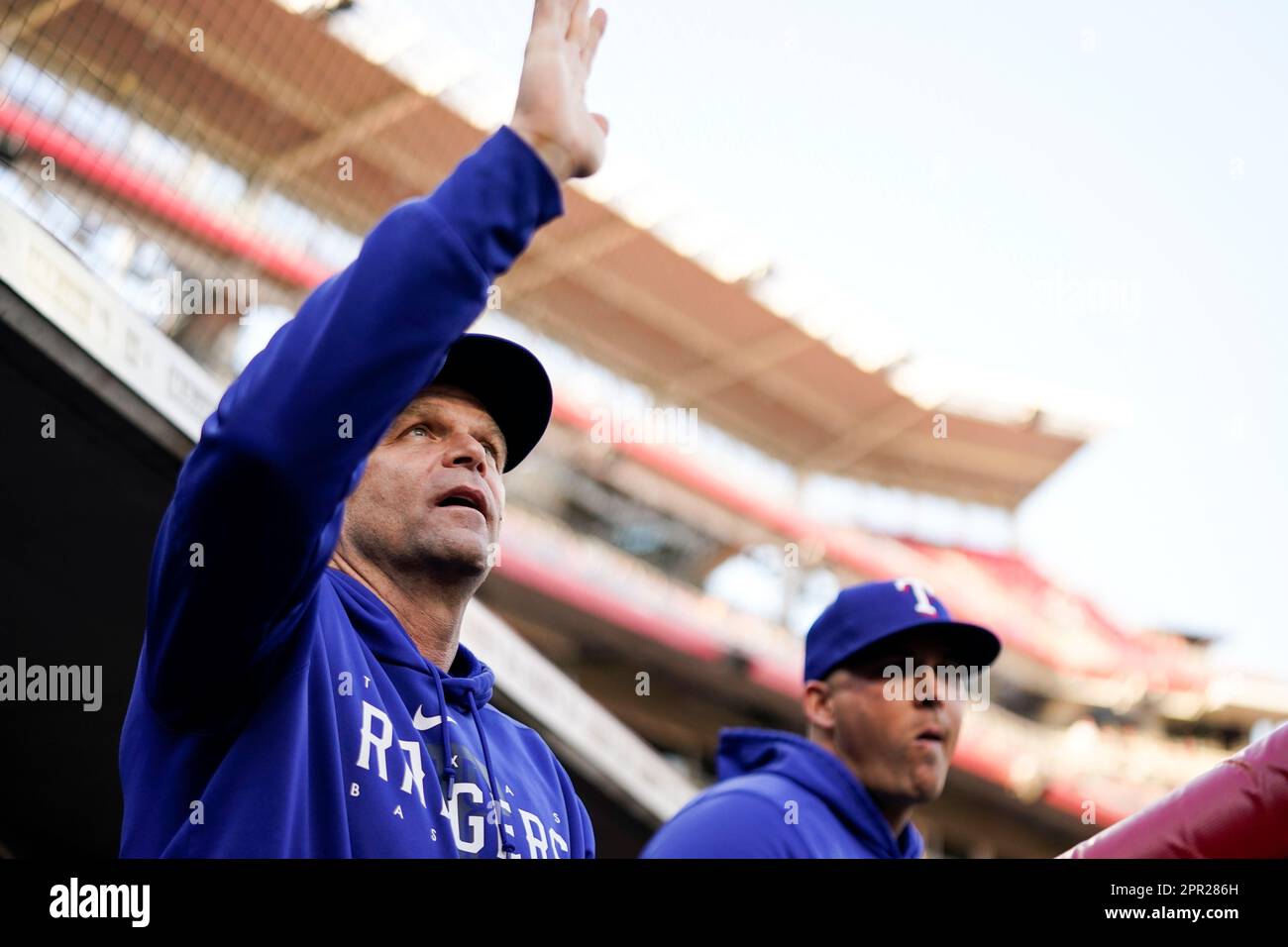 Texas Rangers hitting coach Tim Hyers, left, stands in the dugout in a ...