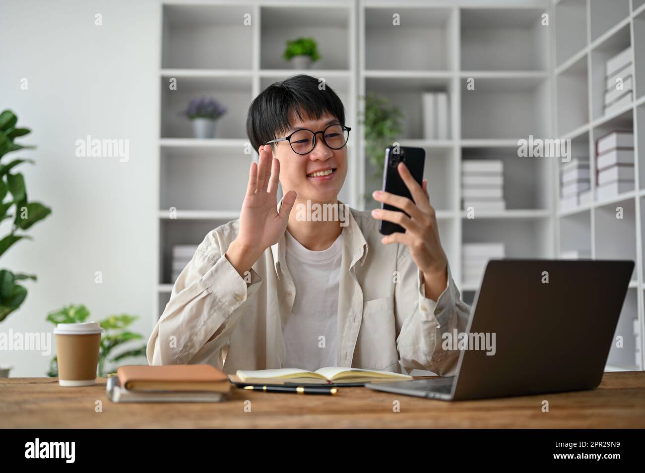 Young cheerful college student video call with his family during a ...