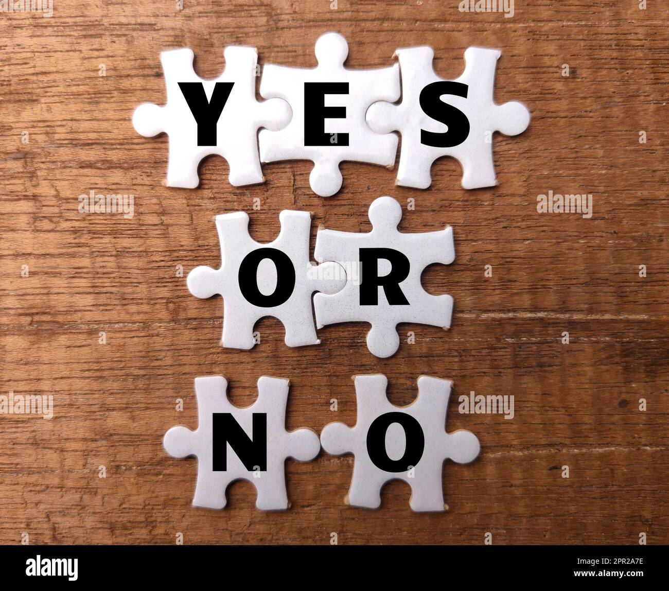 Top view white puzzle with the word YES OR NO on wooden background ...