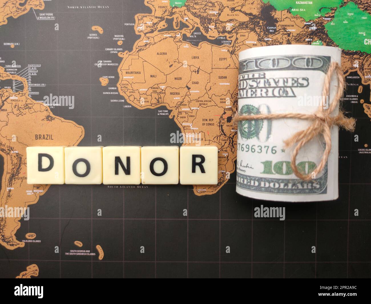 Toys word and banknotes with the word DONOR on a world map background ...