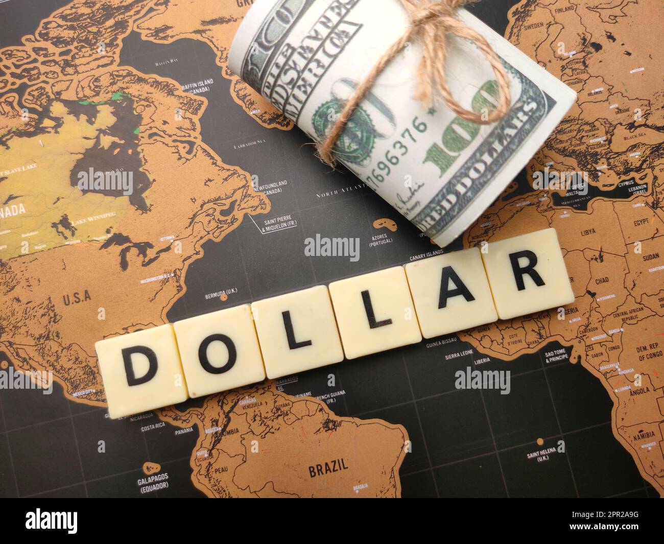 Toys word and banknotes with the word DOLLAR on a world map background ...