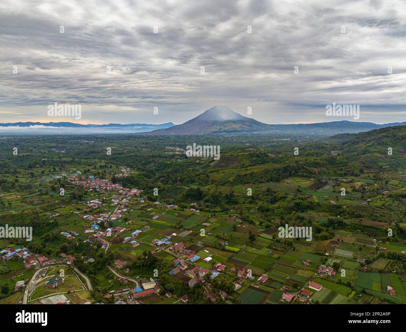Aerial view of Berastagi city and Sinabung volcano at sunset. Sumatra ...