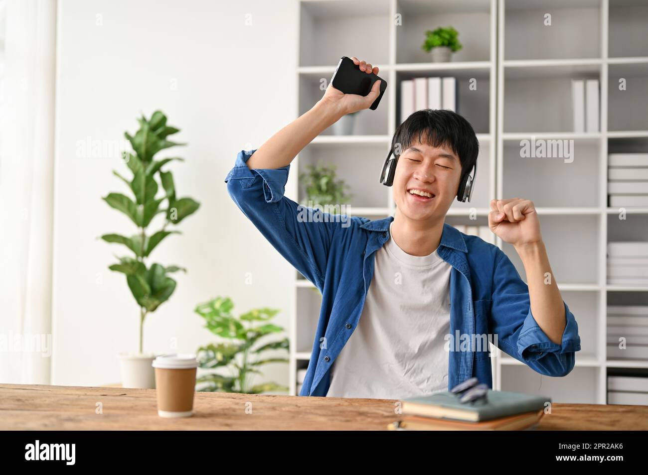 Happy young college student enjoy himself, listening to music while ...