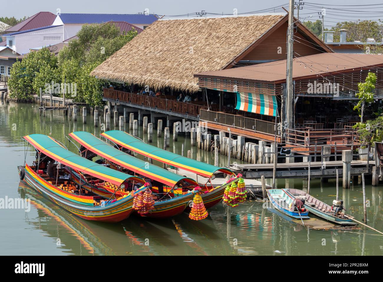 Traditional wooden boats decorated with flowers on the nose are moored ...