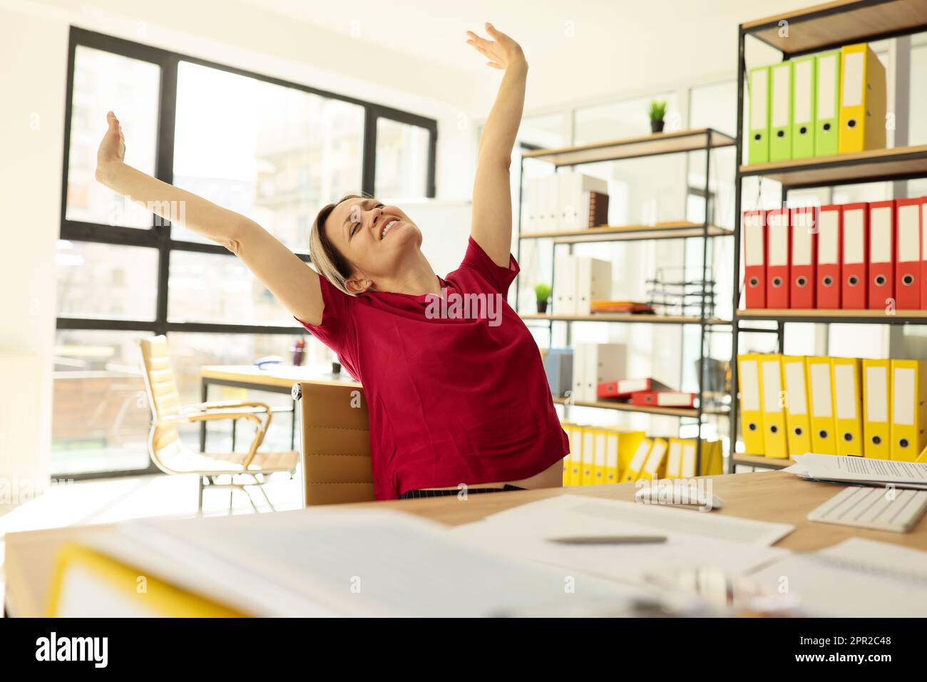 Happy woman stretches back and arms after finishing report Stock Photo ...