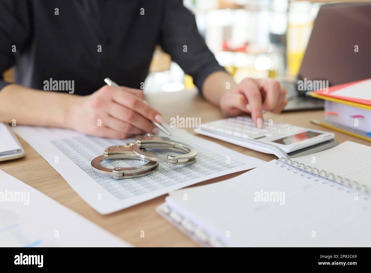 Handcuffs on investigation paper while woman making counts Stock Photo ...