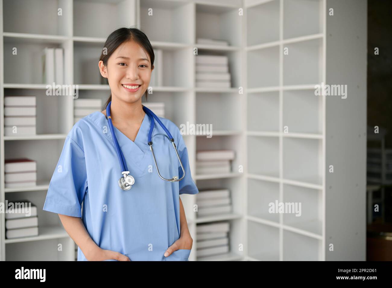 Portrait of young Asian medical student smiling and standing in the ...