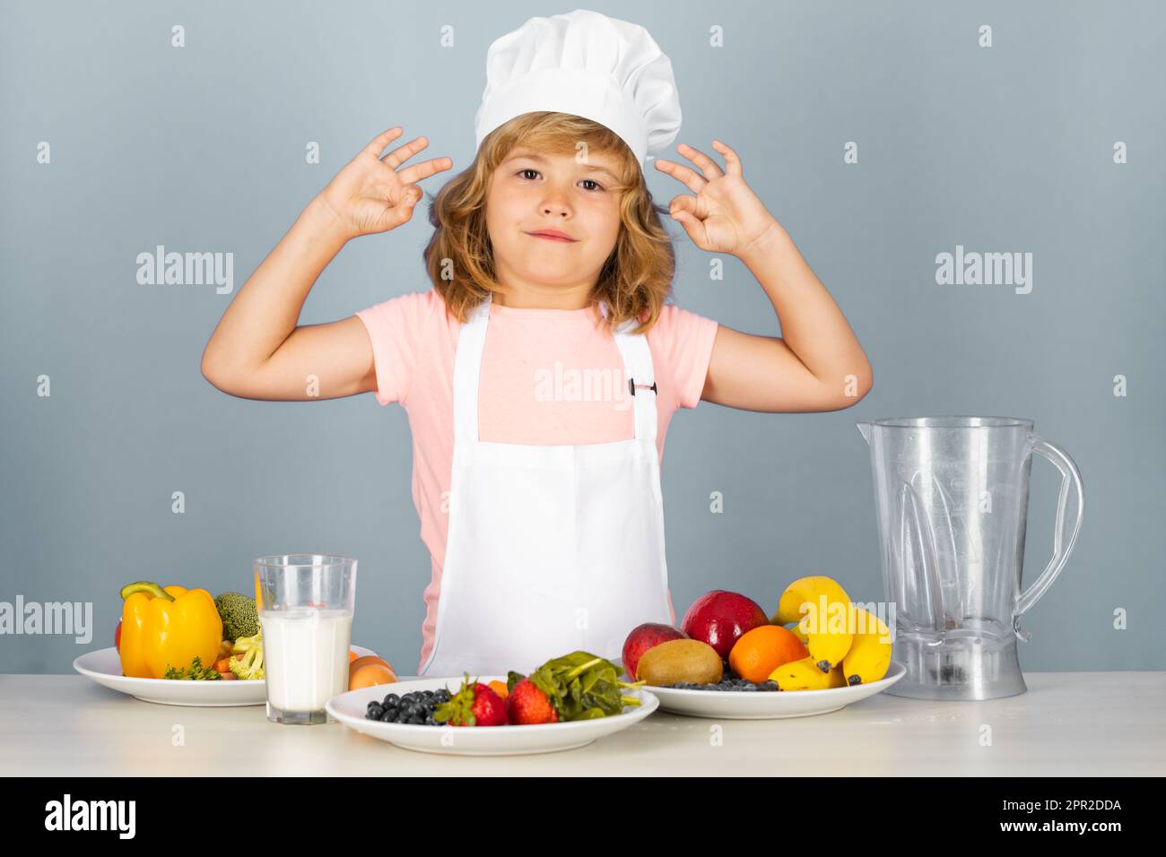 Fruits and vegetables for kids. Child chef cook prepares food on ...