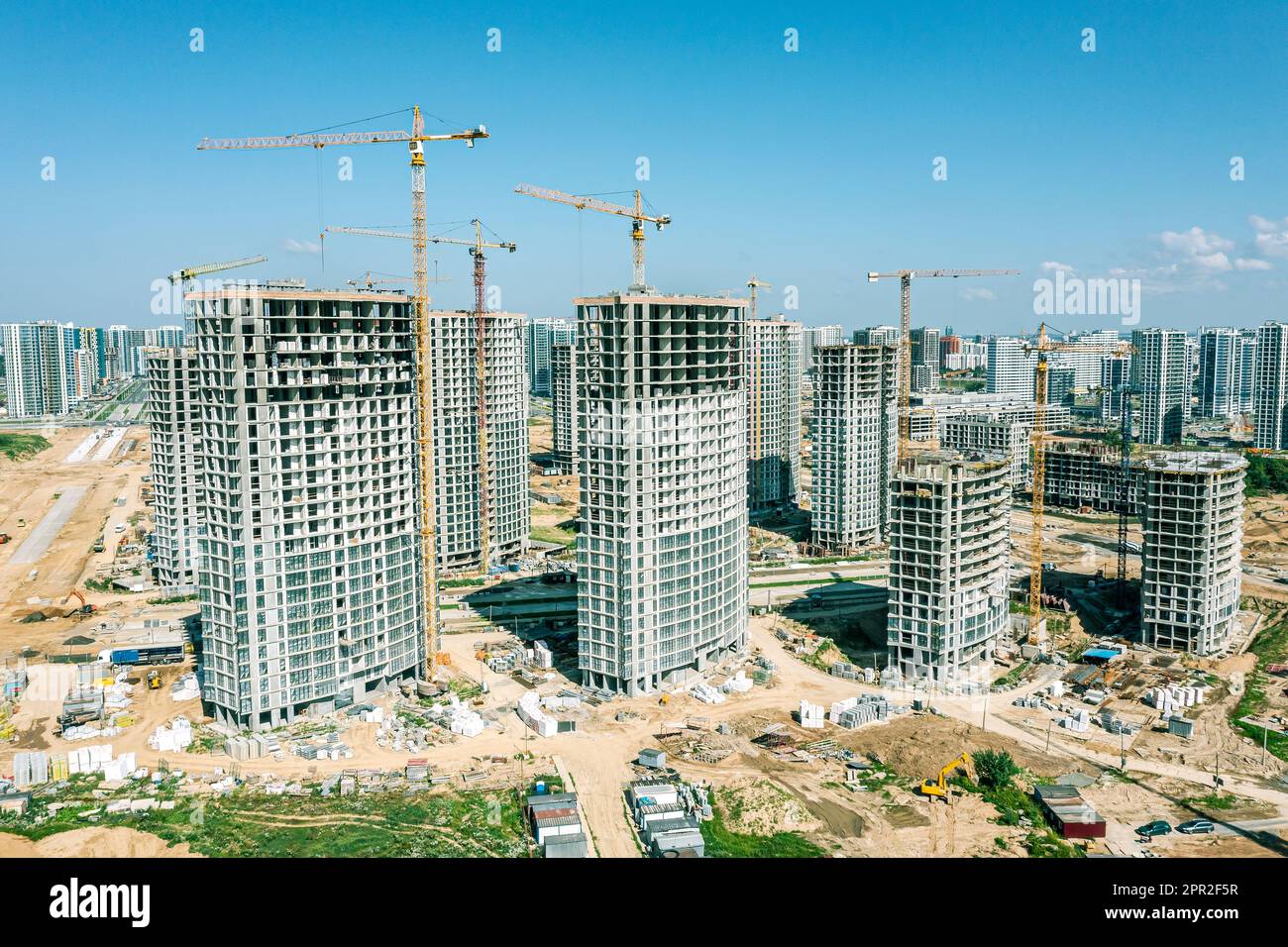 high-rise apartment buildings under construction with cranes on clear ...