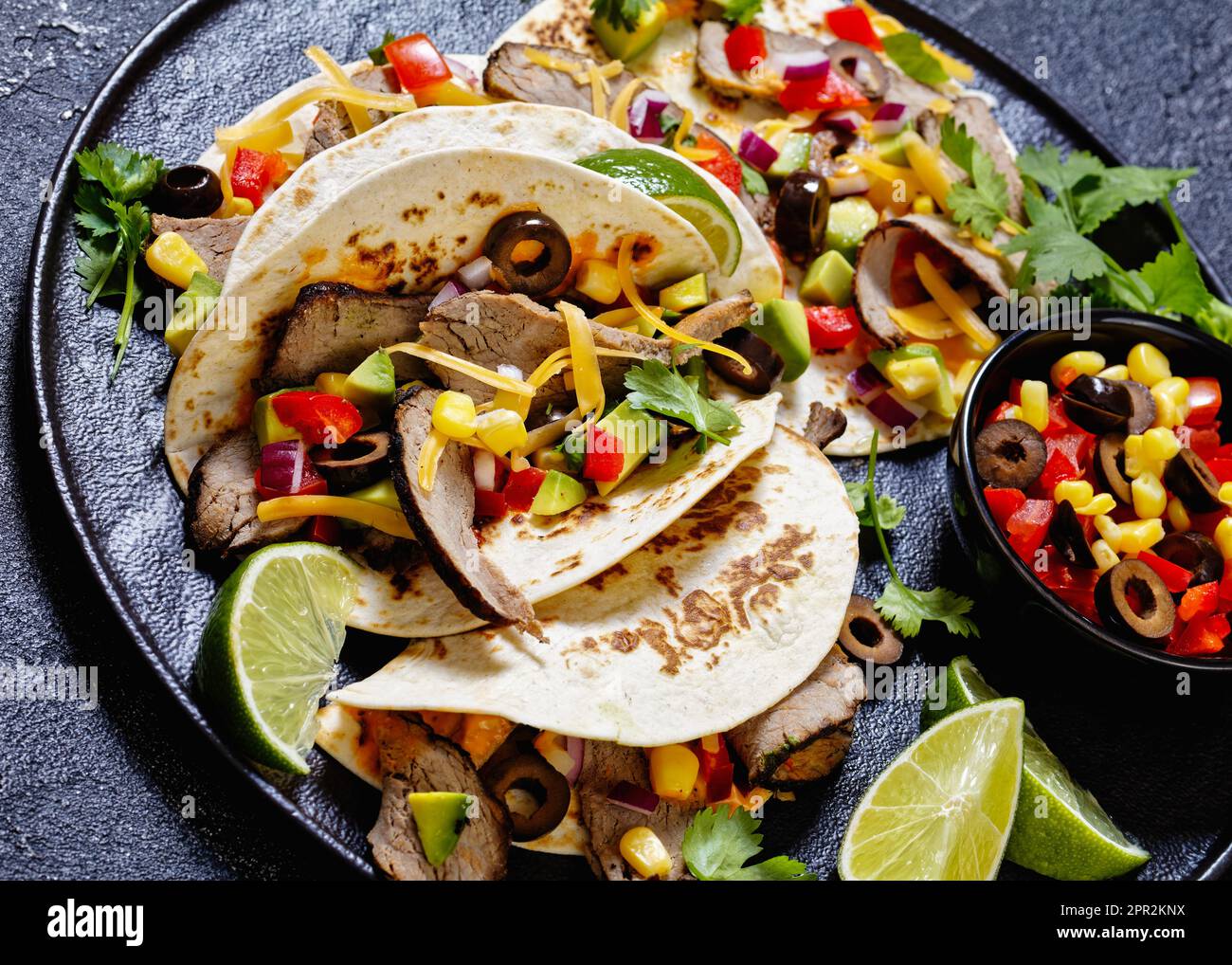 close-up of Grilled Steak Tacos with olives, tomatoes, red onion ...