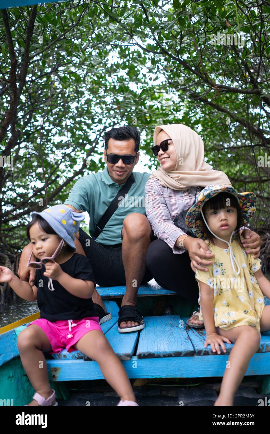 a husband and wife and their children are riding a small boat in the ...