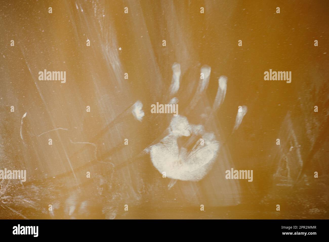 A child's palm print and dirt on the window glass from hands. Traces of ...