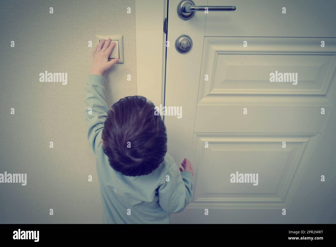 Little baby turns on the light by pressing the switch. Small child ...