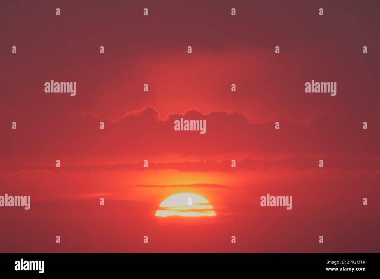 Sunset sky with red light of the setting sun. Evening clouds in the ...