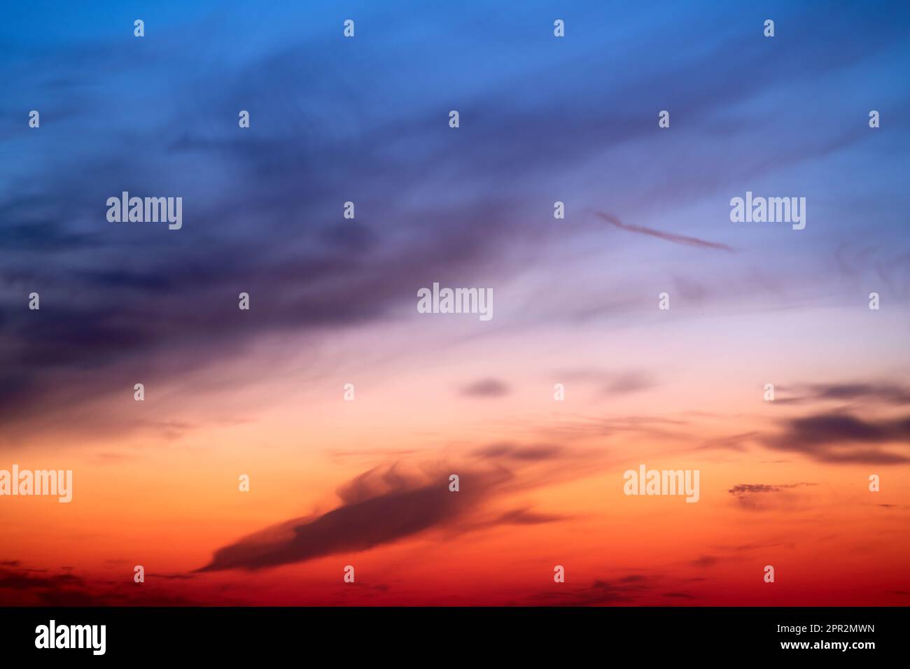 Sunset sky with red light of the setting sun. Evening clouds in the ...
