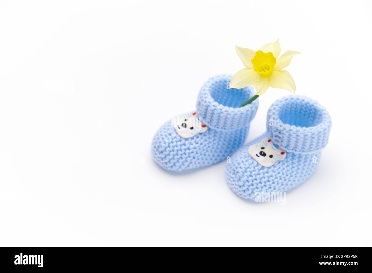 Top view of a pair of handmade blue knitted baby booties and yellow ...