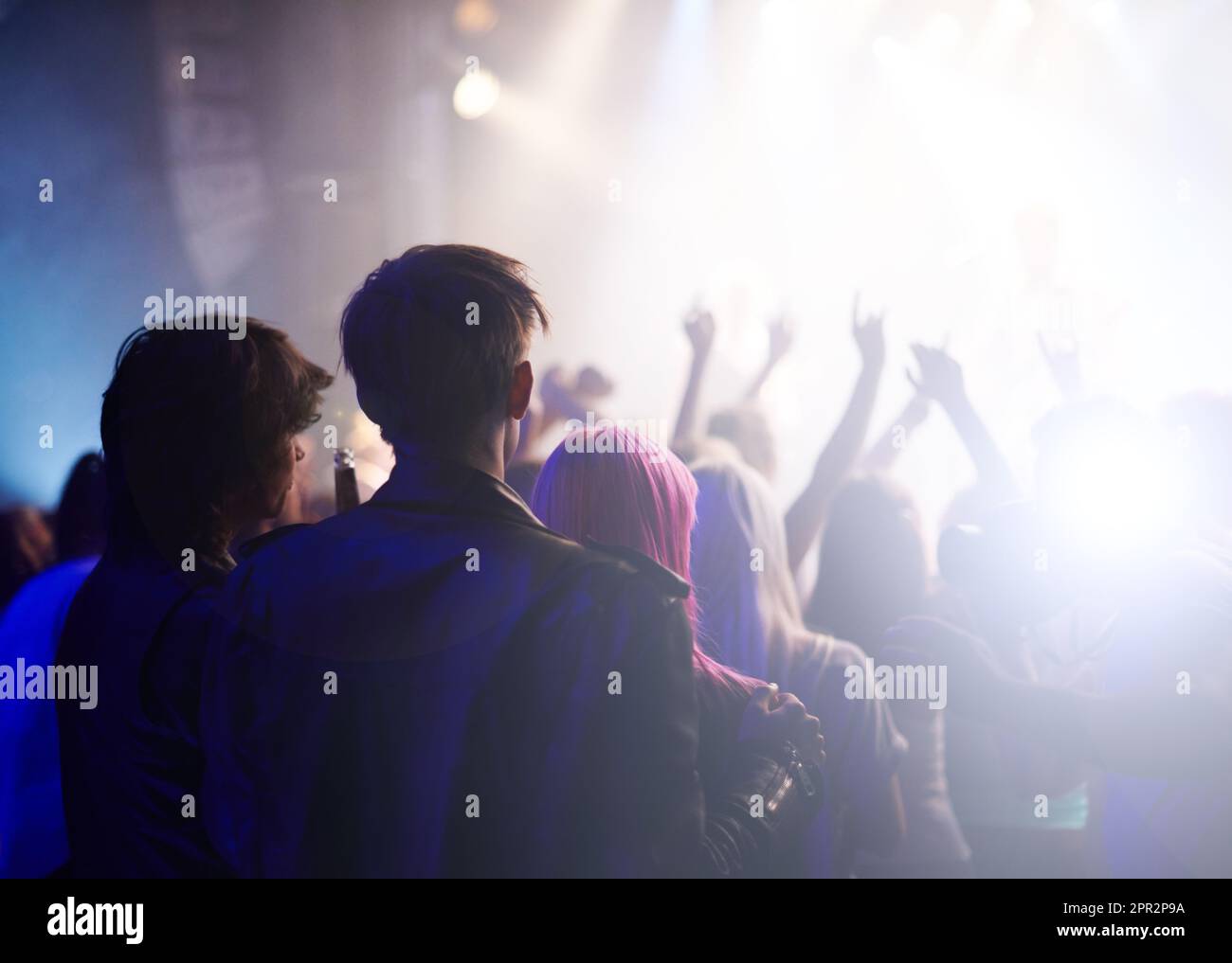Dance, rock and friends in crowd at music festival from back, watching ...
