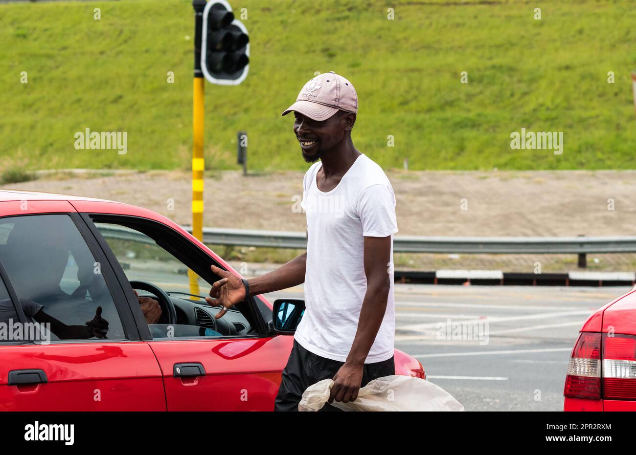 African man, beggar walking around cars or vehicles at the traffic ...