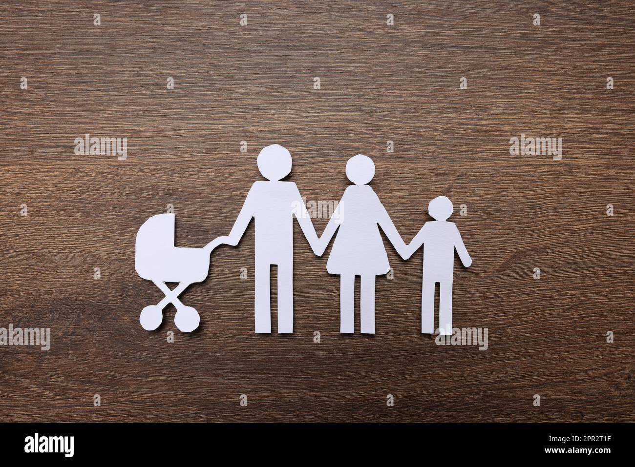 Paper family cutout on wooden background, top view. Insurance concept ...