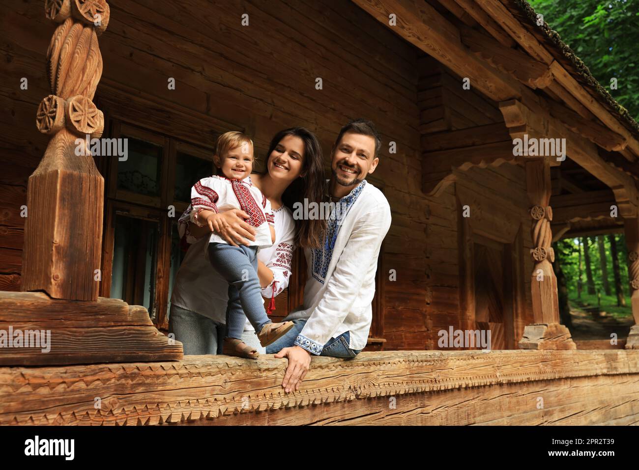 Happy family in Ukrainian national clothes on wooden terrace Stock ...