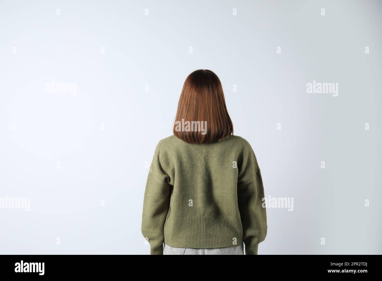 Girl wearing cardigan on white background, back view Stock Photo - Alamy