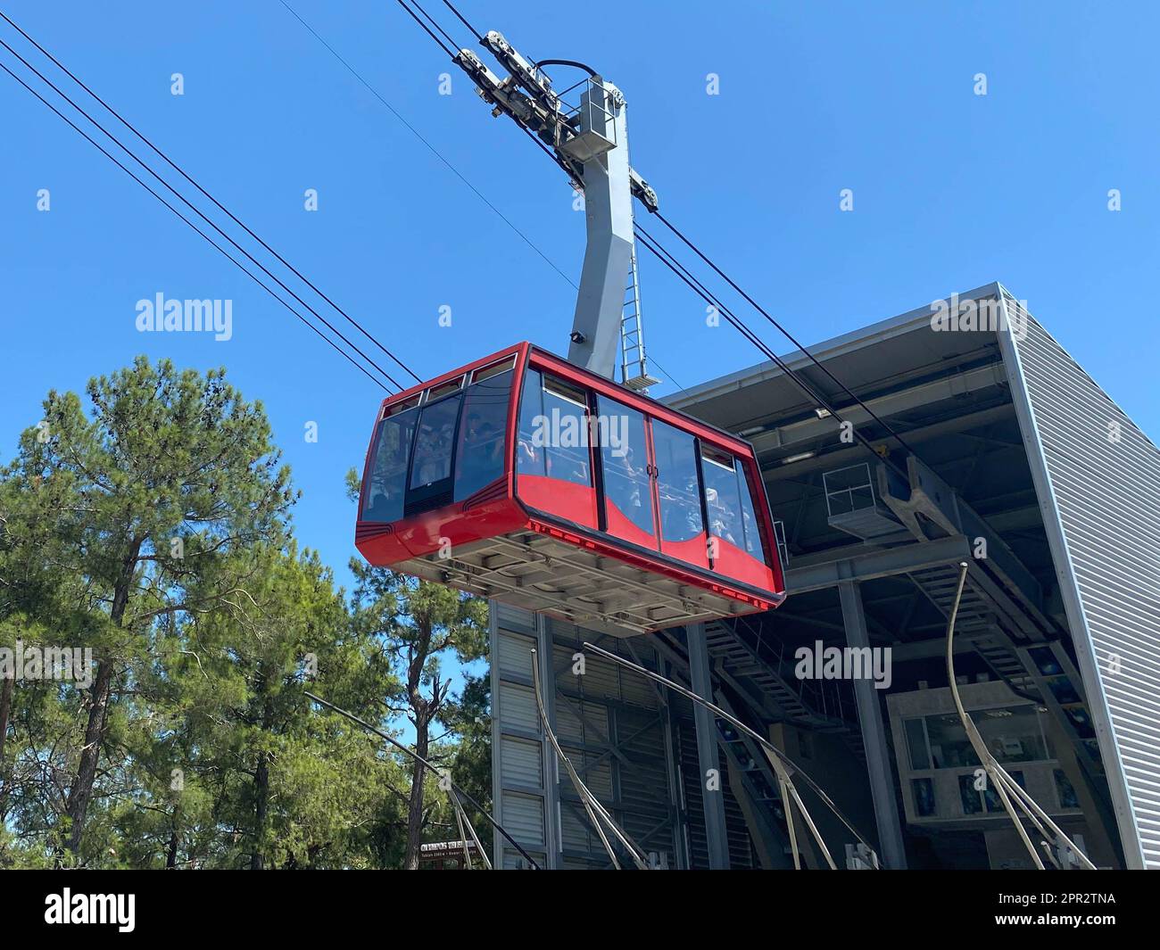 Red modern tourist cabin of the cable car ascends the mountains against ...