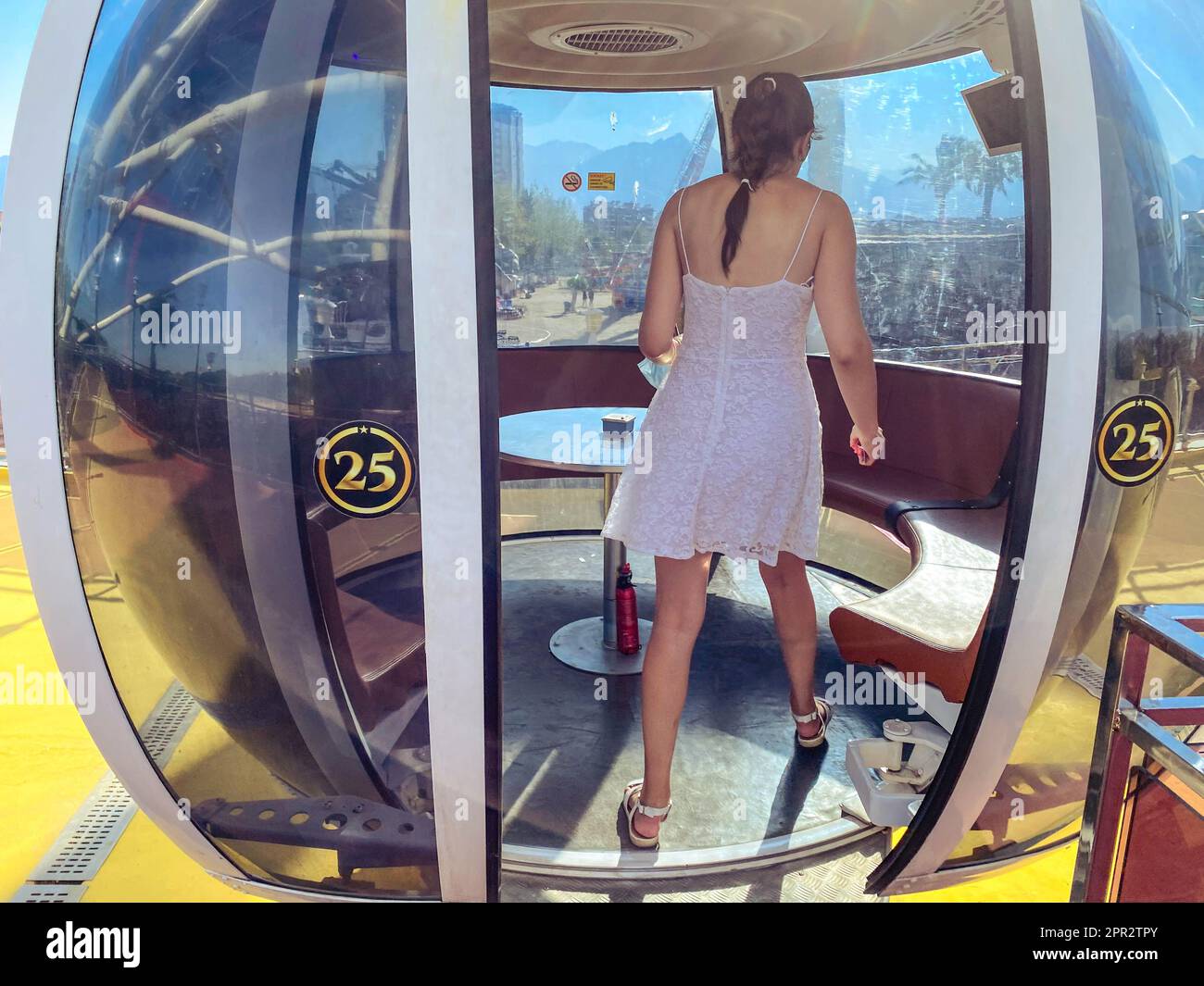 ride on a ferris wheel. a girl with long hair in a white dress enters a ...