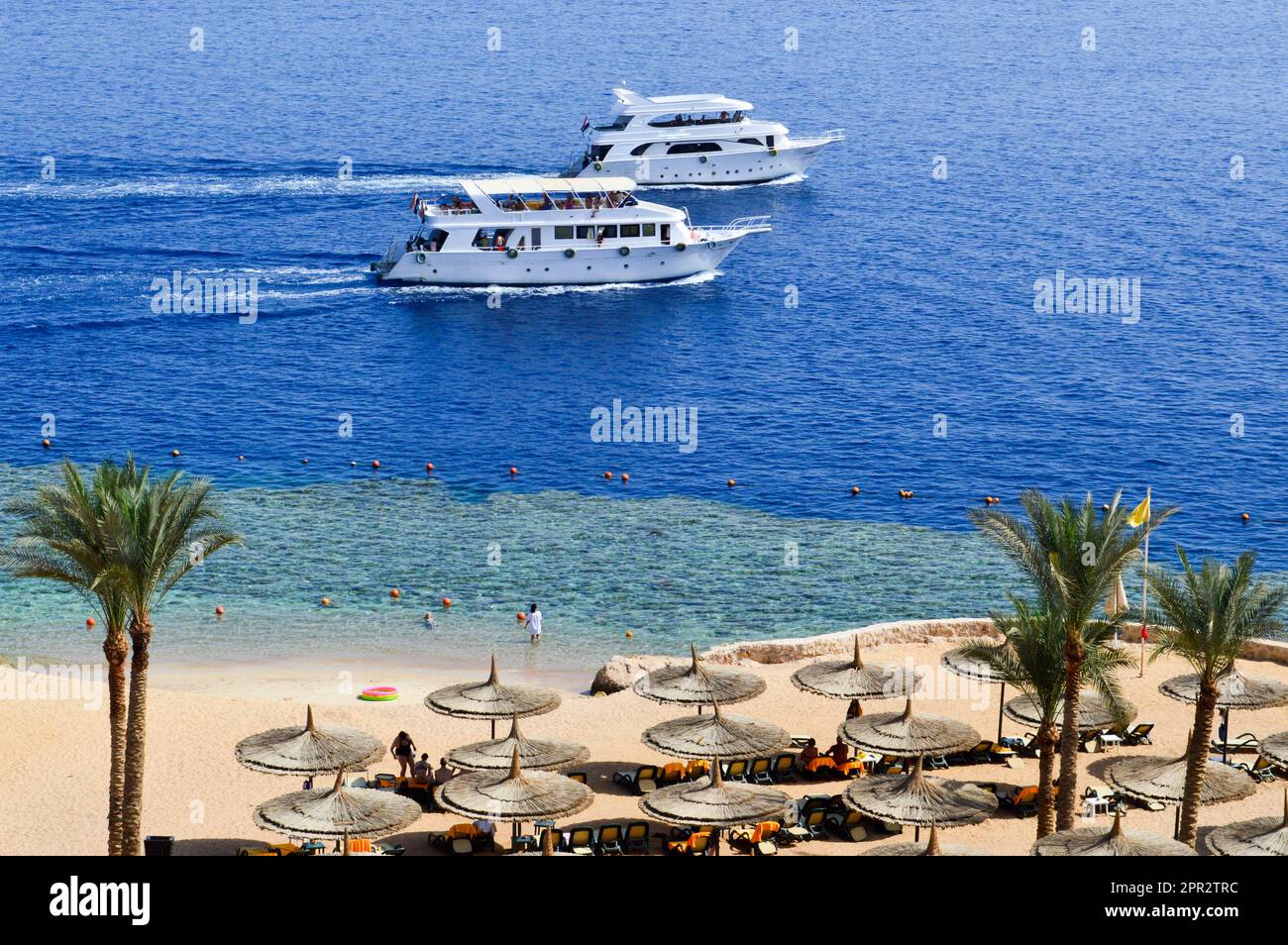 Top view of a sandy beach with sunbeds and sun umbrellas and two large ...