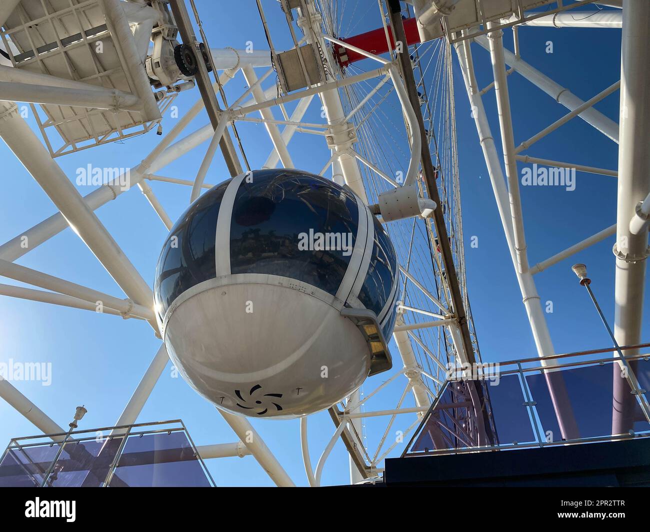 A large Ferris wheel against a blue sky. Booths with people go up Stock ...