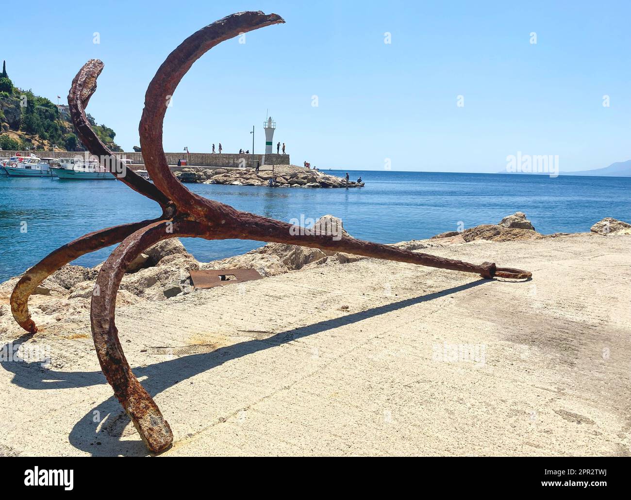old, rusty anchor on the seashore. at the port with ships and yachts ...
