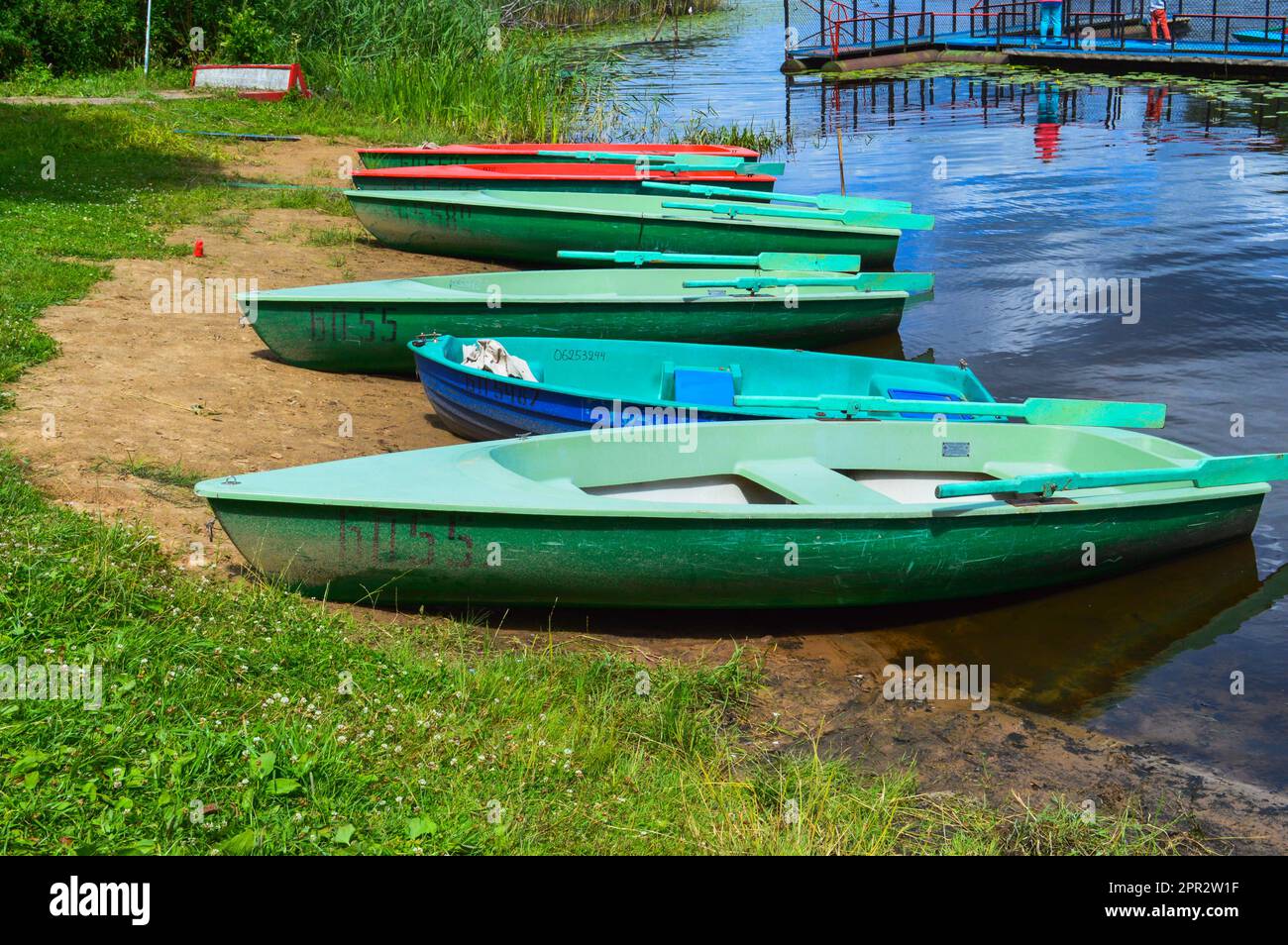 Beautiful wooden multicolored boats with oars on the beach for walks ...