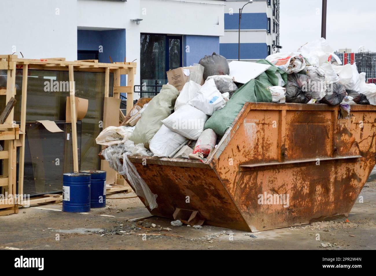Large iron industrial trash can. A mess with garbage with dirt, poor ...