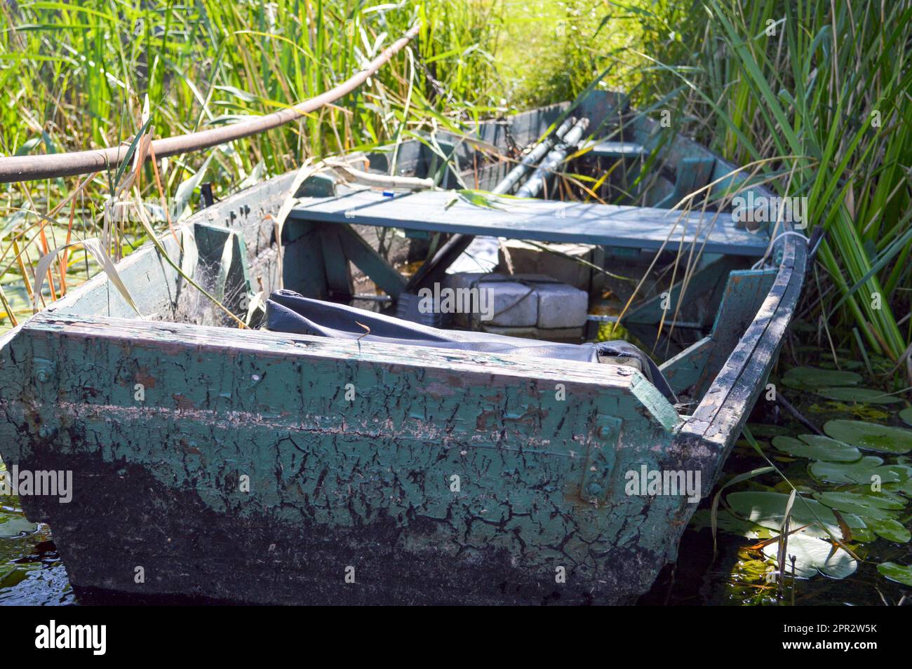 Old wooden shabby dilapidated broken boat for swimming on the banks of ...